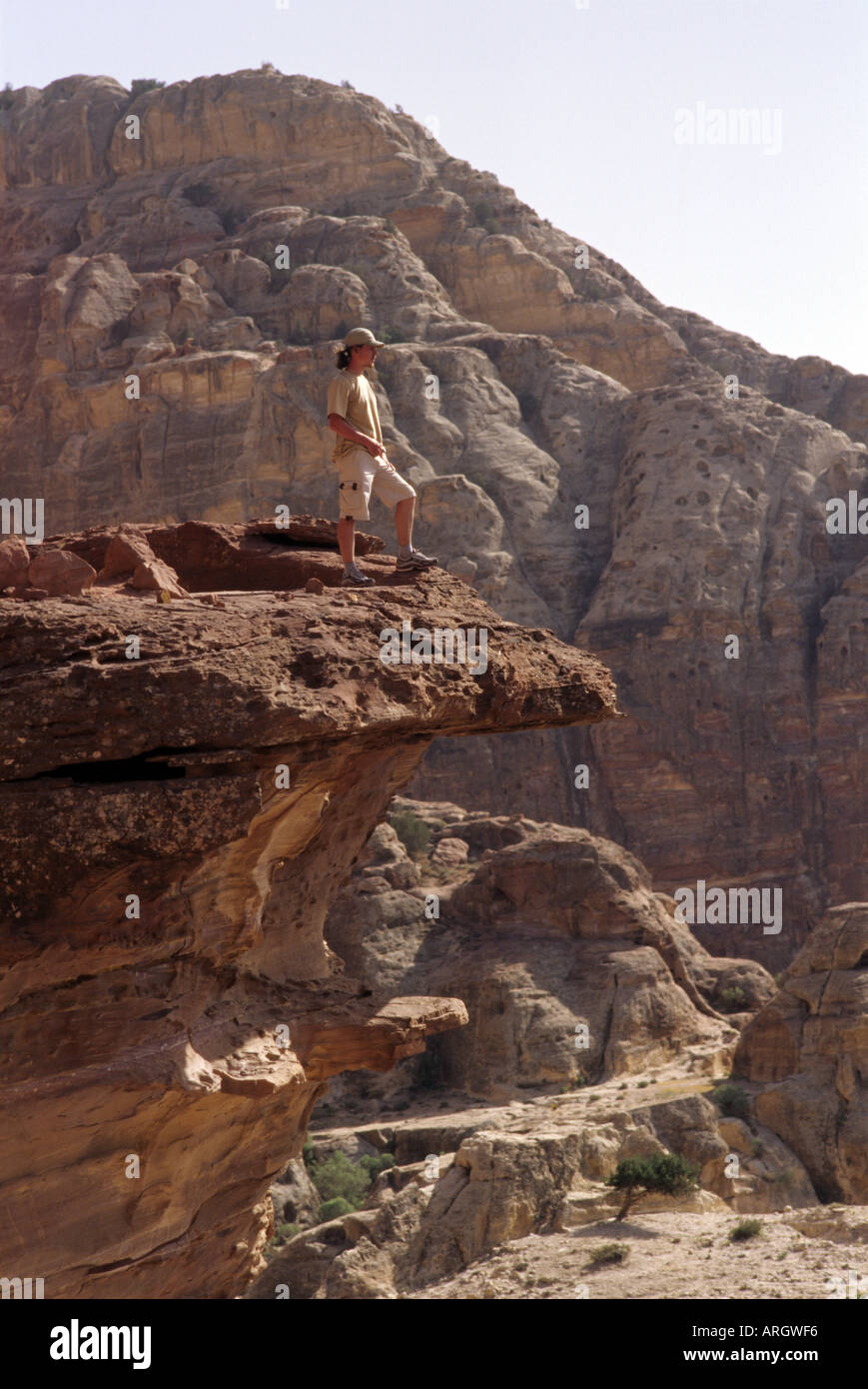 Petra Jordan. A man standing on the edge of a rock Stock Photo - Alamy