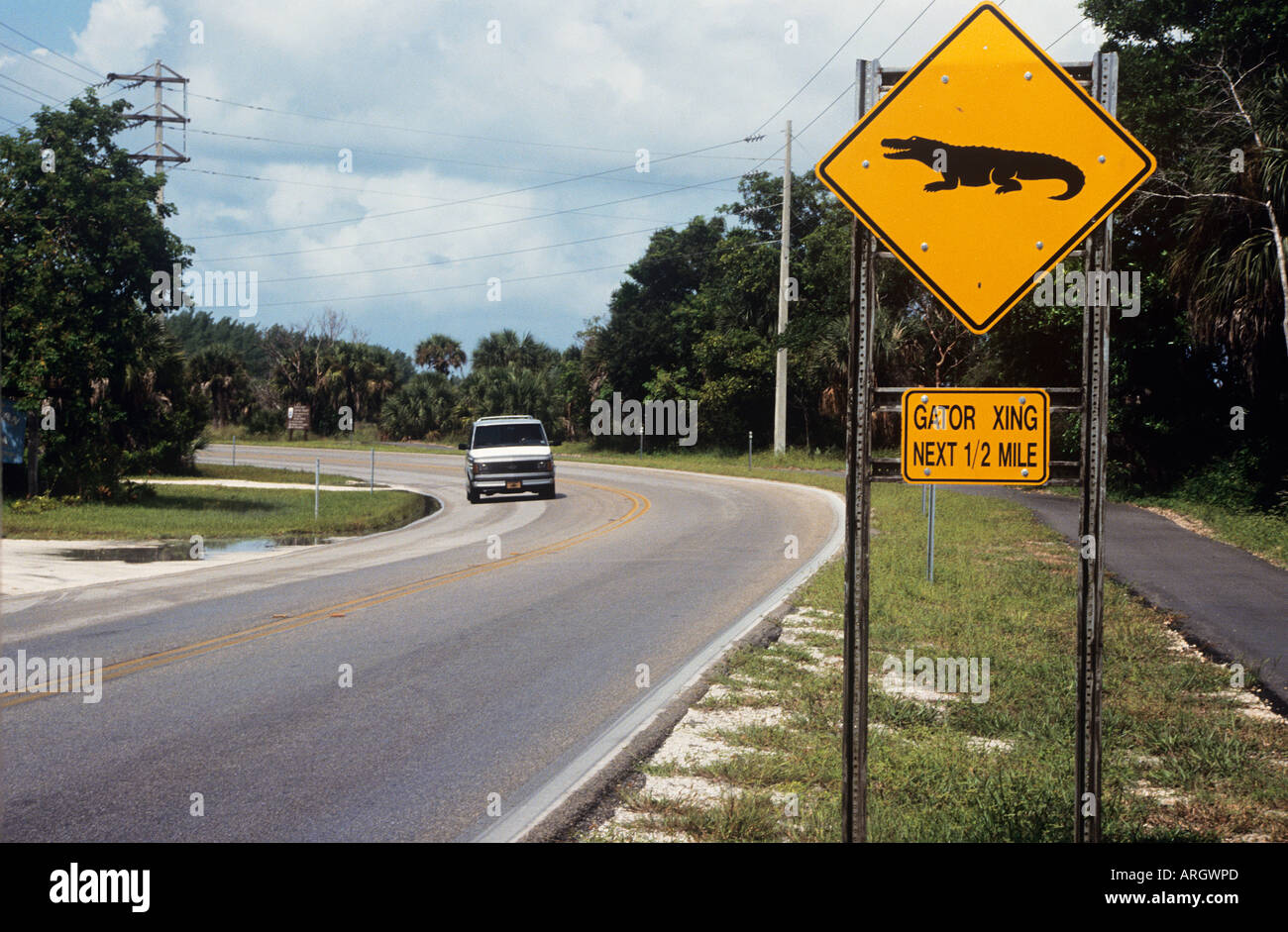 A vehicle approaching an unusual road sign indicating that gators will ...