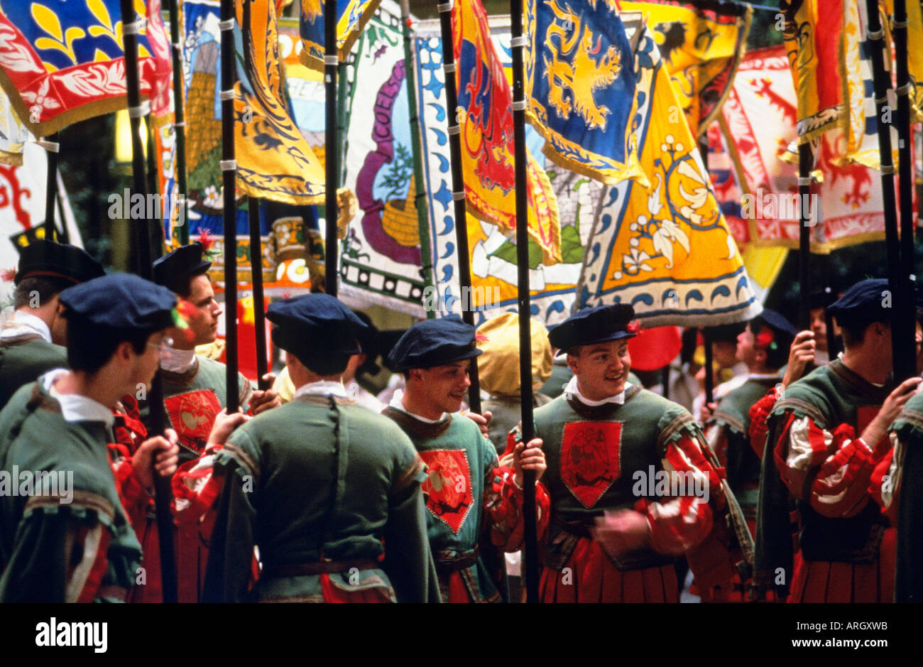 A number of locals in Medieval style costume carrying a mass of ...