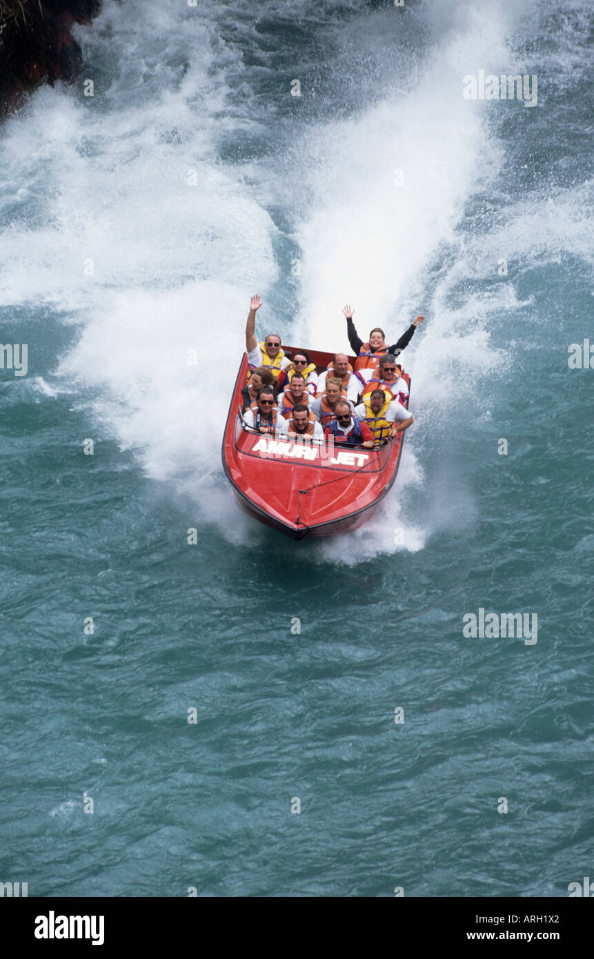 The passengers of a jet boat ride on the dark water of a fast flowing ...