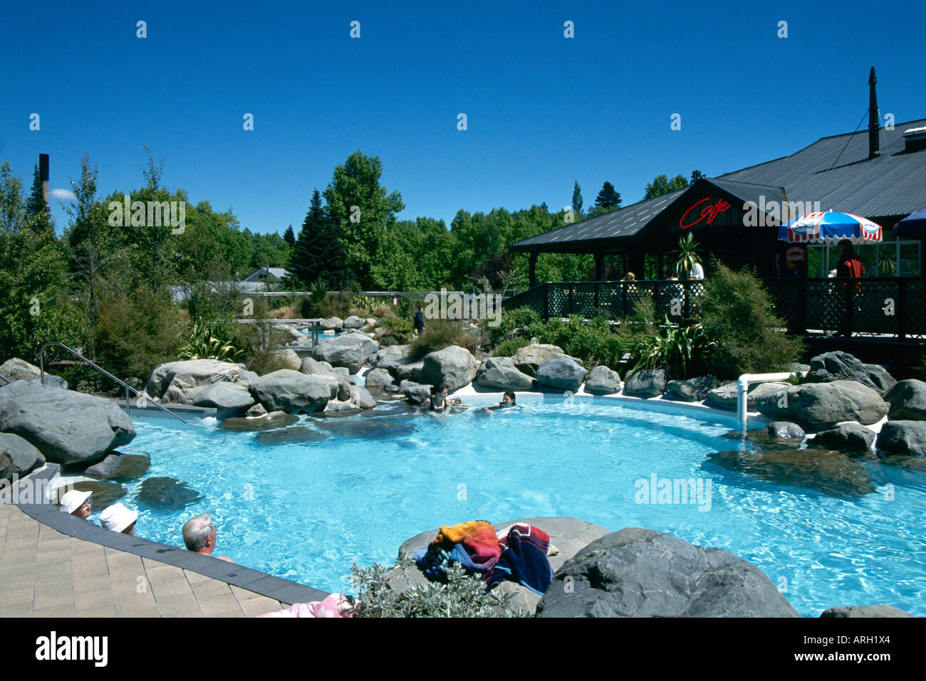 A person relaxes in one of the landscaped out door hot pools of the ...