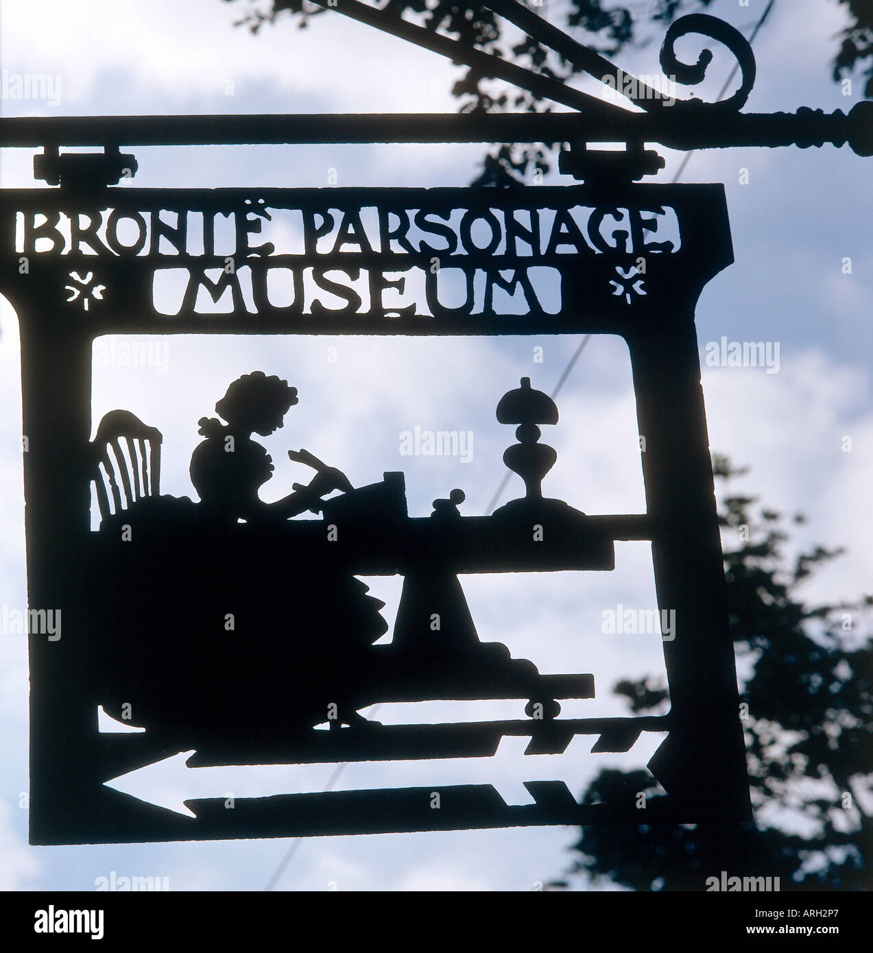 A sign made from a metal cut out depicting a girl writing at a desk at ...