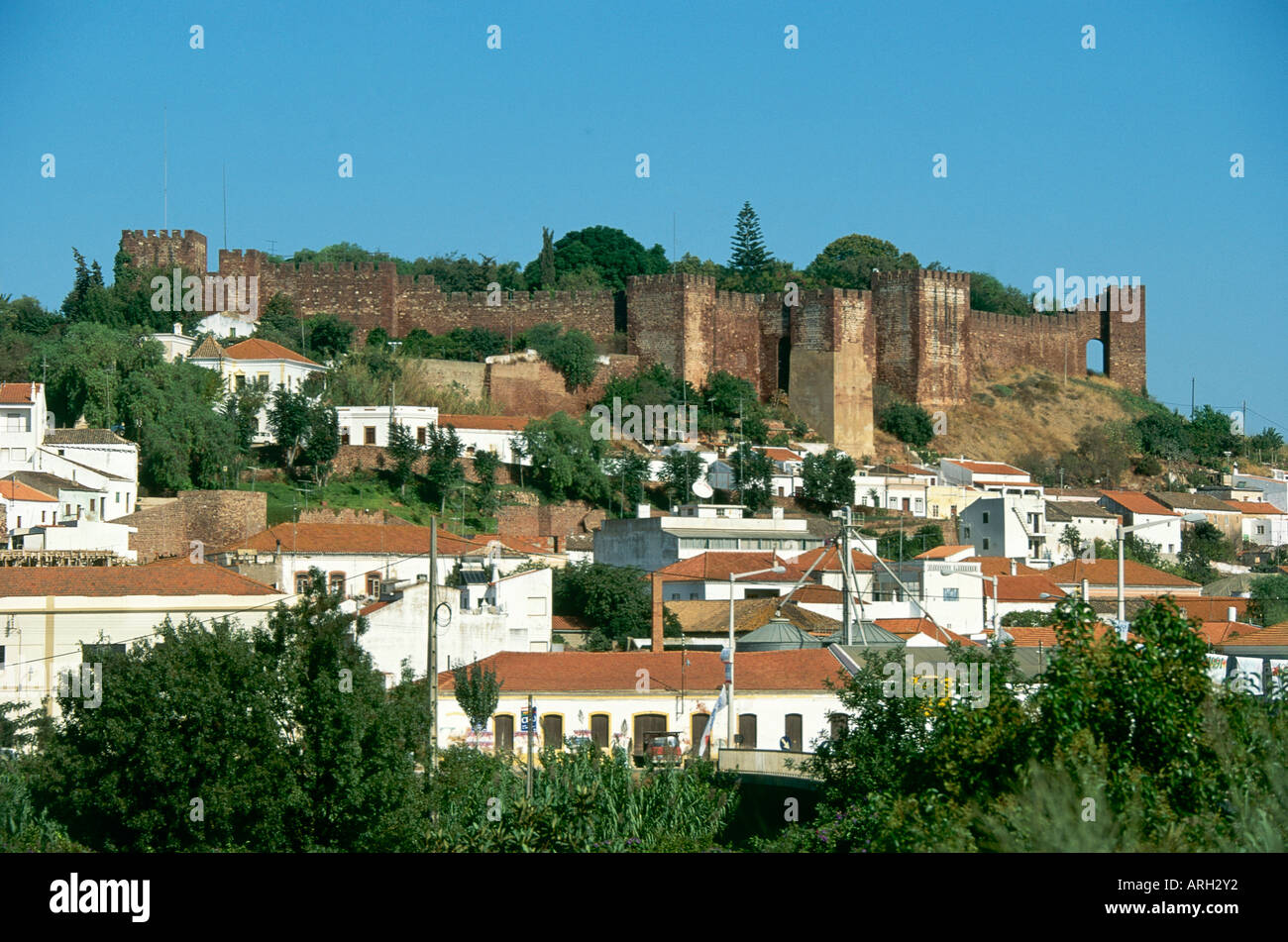 The whitewashed buildings of Silves topped with red tiled roofs beneath ...