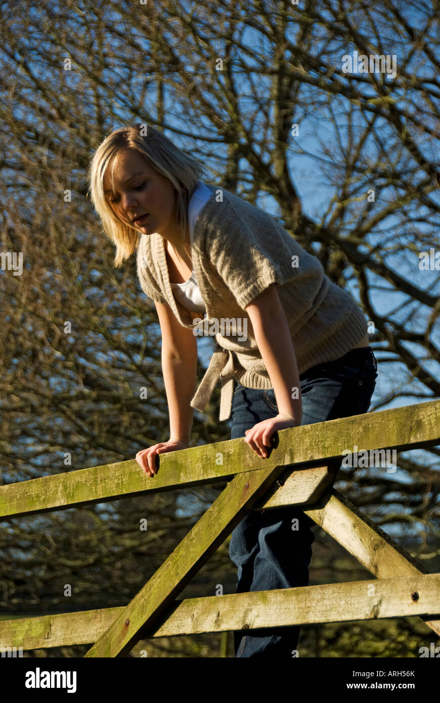 teenage girl climbing over farm gate Stock Photo - Alamy