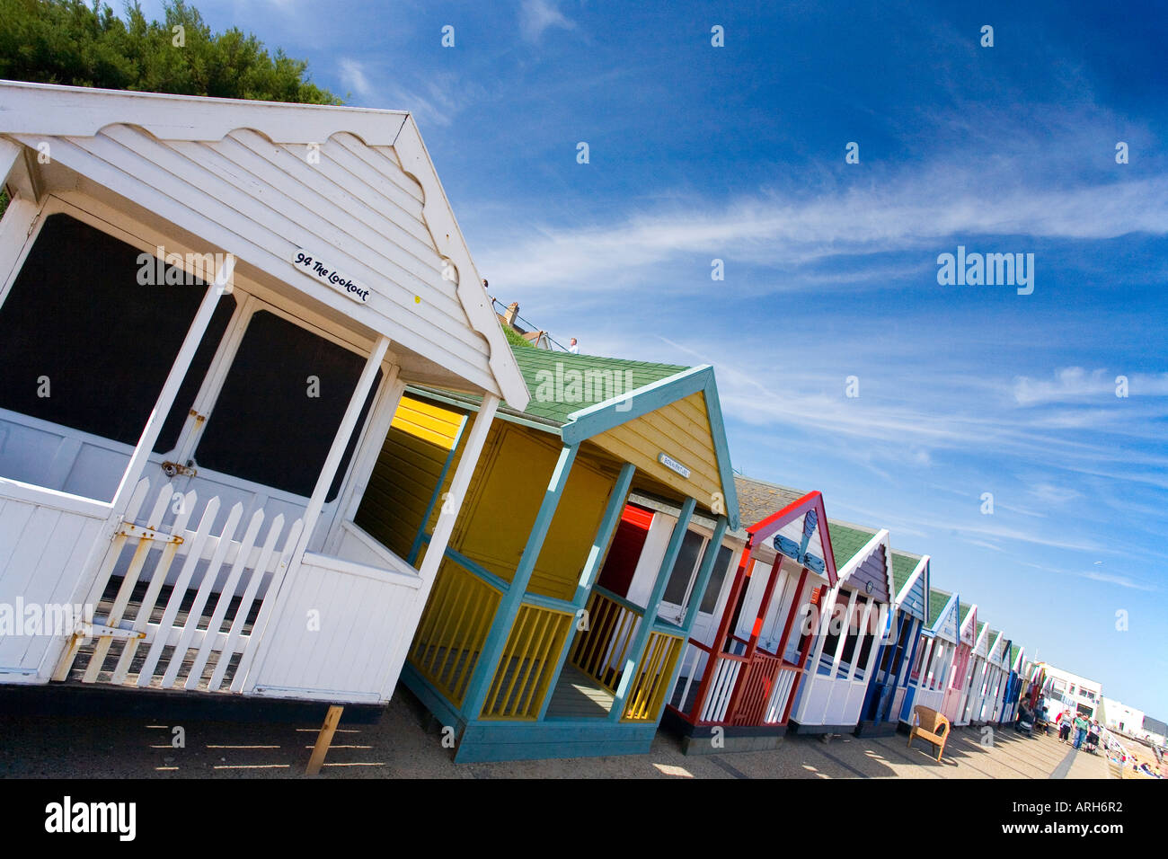 Beach huts in summer sun sunshine with blue sky by the sea seaside in ...