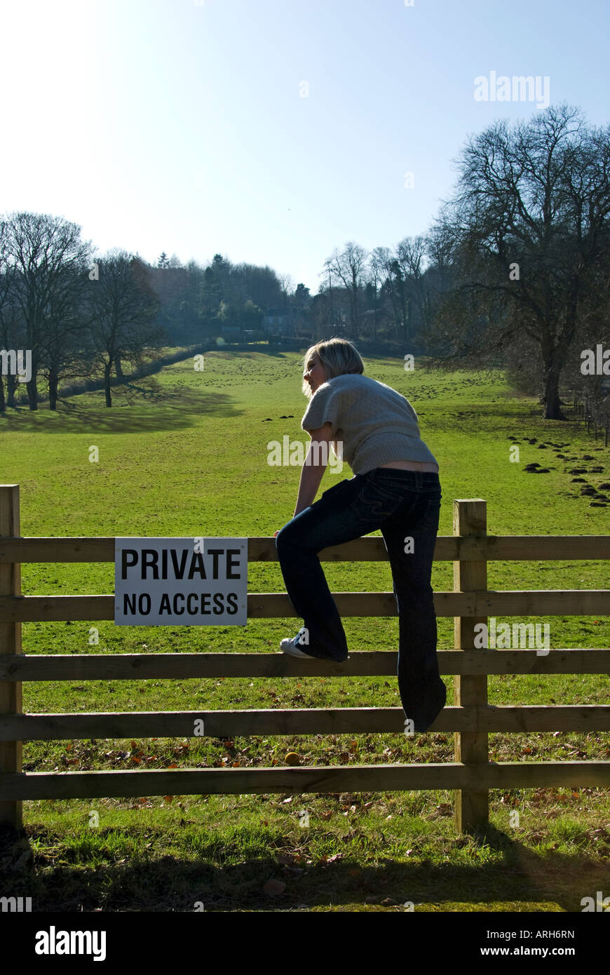 teenage girl climbing over fence Stock Photo - Alamy