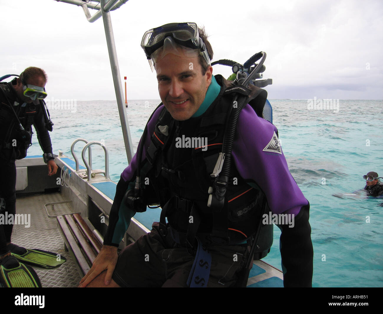 Portrait of a young man wearing scuba gear sitting in a boat Moorea ...