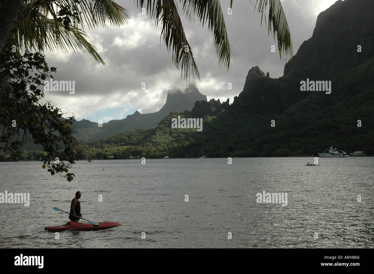 A man in a rowboat in water Moorea Tahiti French Polynesia South ...