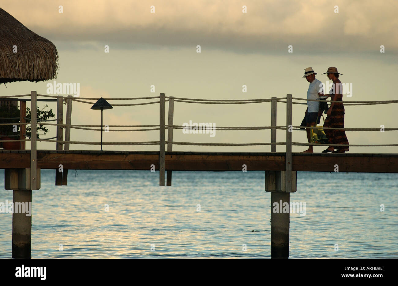 A mid adult couple walking on a pier Moorea Tahiti French Polynesia ...
