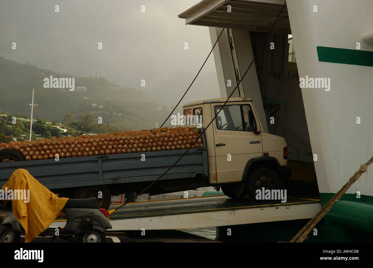A truck loaded with pineapples being loaded into a barge Papeete Tahiti ...