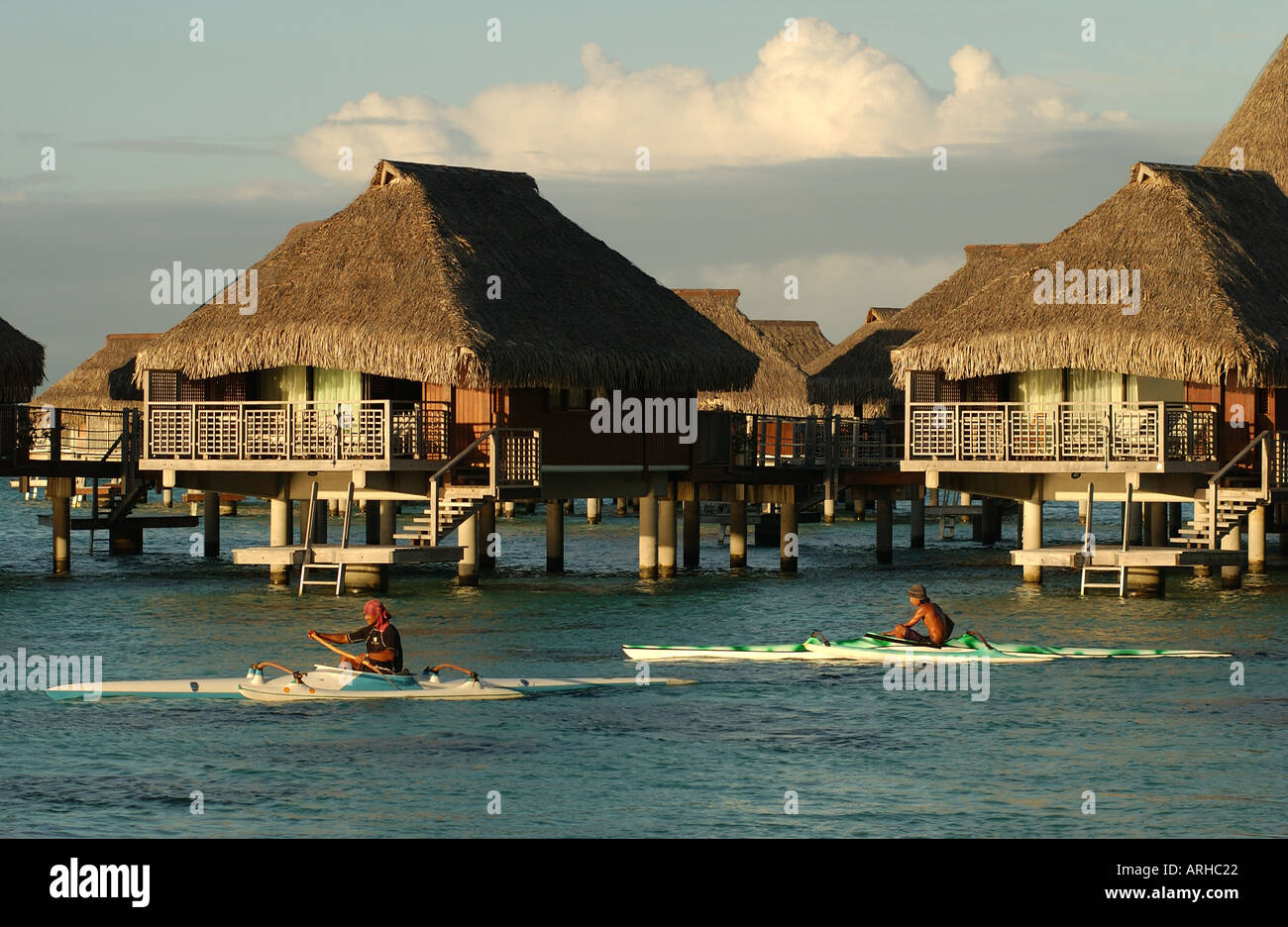 Thatched roof wooden structures built on stilts in the sea Moorea ...