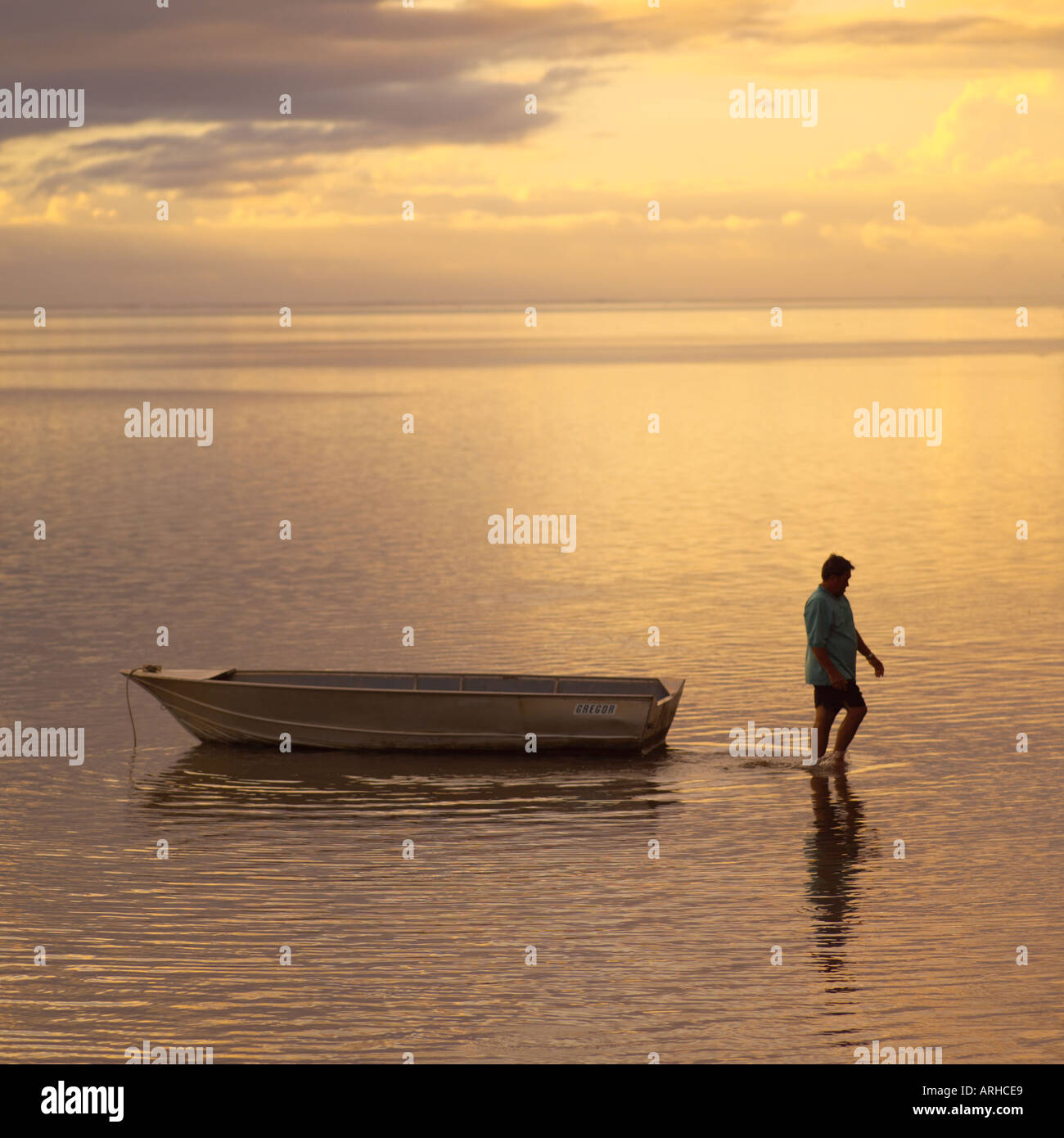 Man walking with boat in ocean at Moorea in Tahiti Stock Photo - Alamy