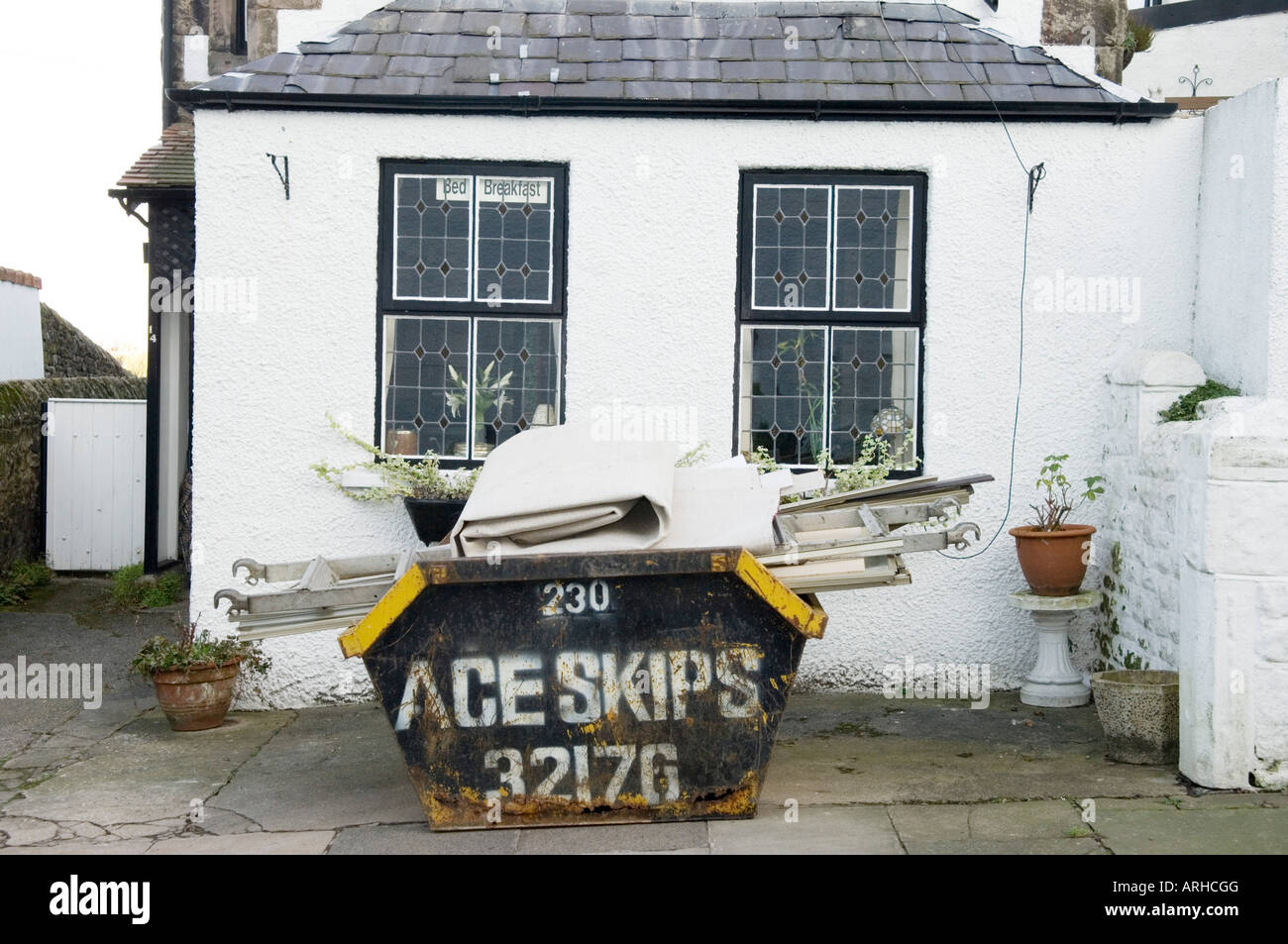 Building skip in front of house Stock Photo - Alamy