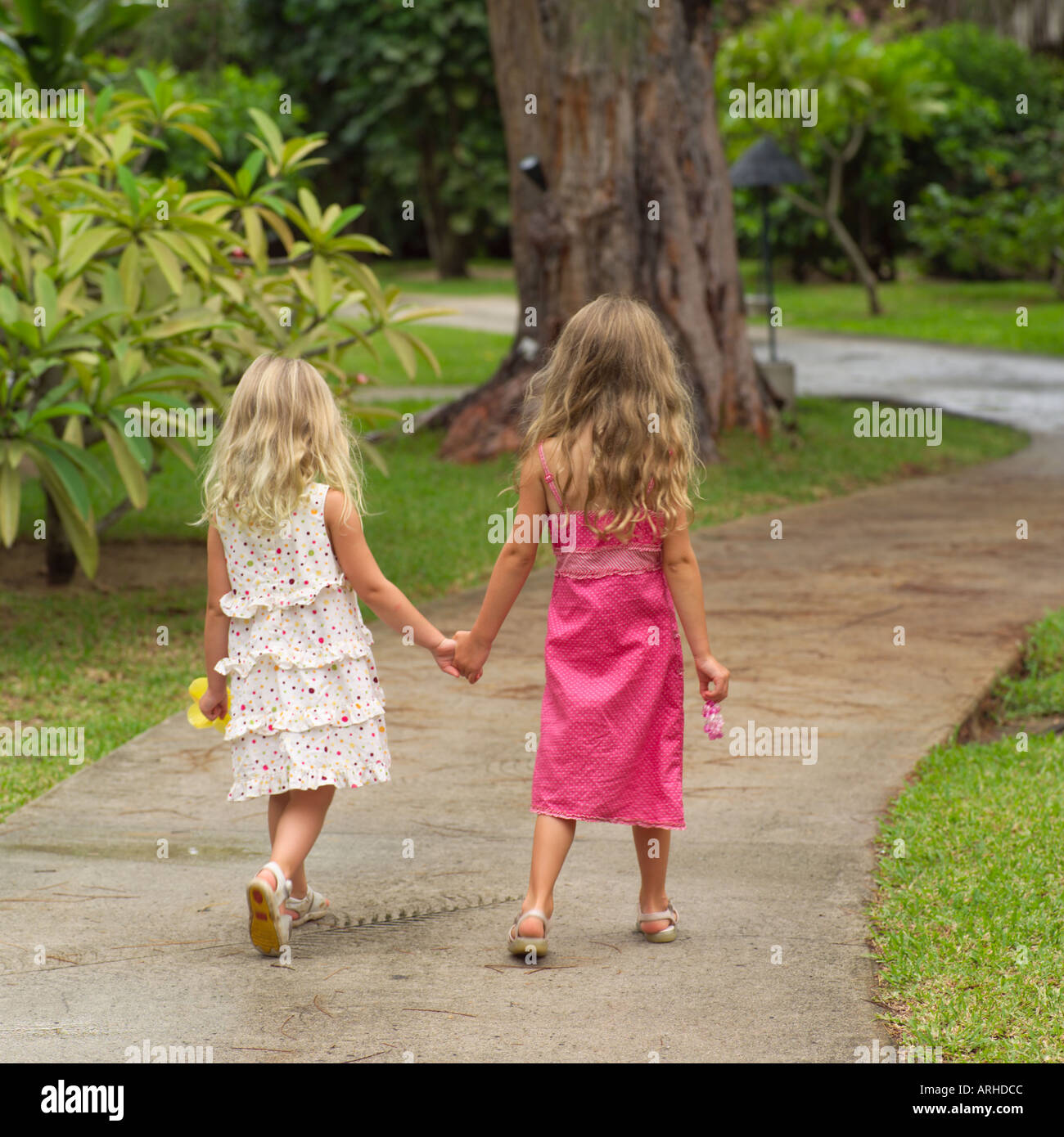 Two Young Girls Walking Hand in Hand at Moorea in Tahiti Stock Photo - Alamy