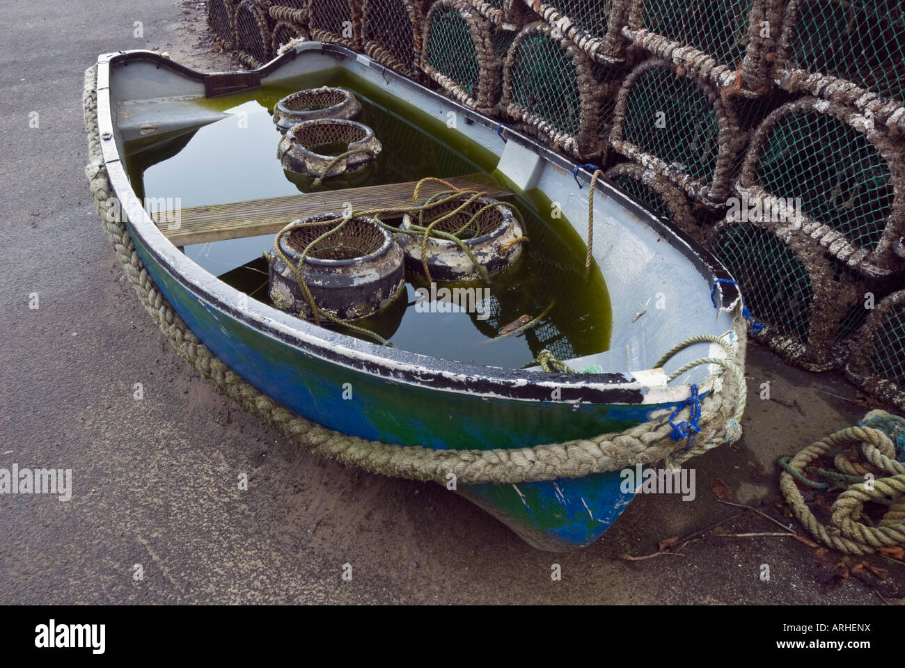 An old boat filled with water and lobster pots at Tenby Harbour, West ...