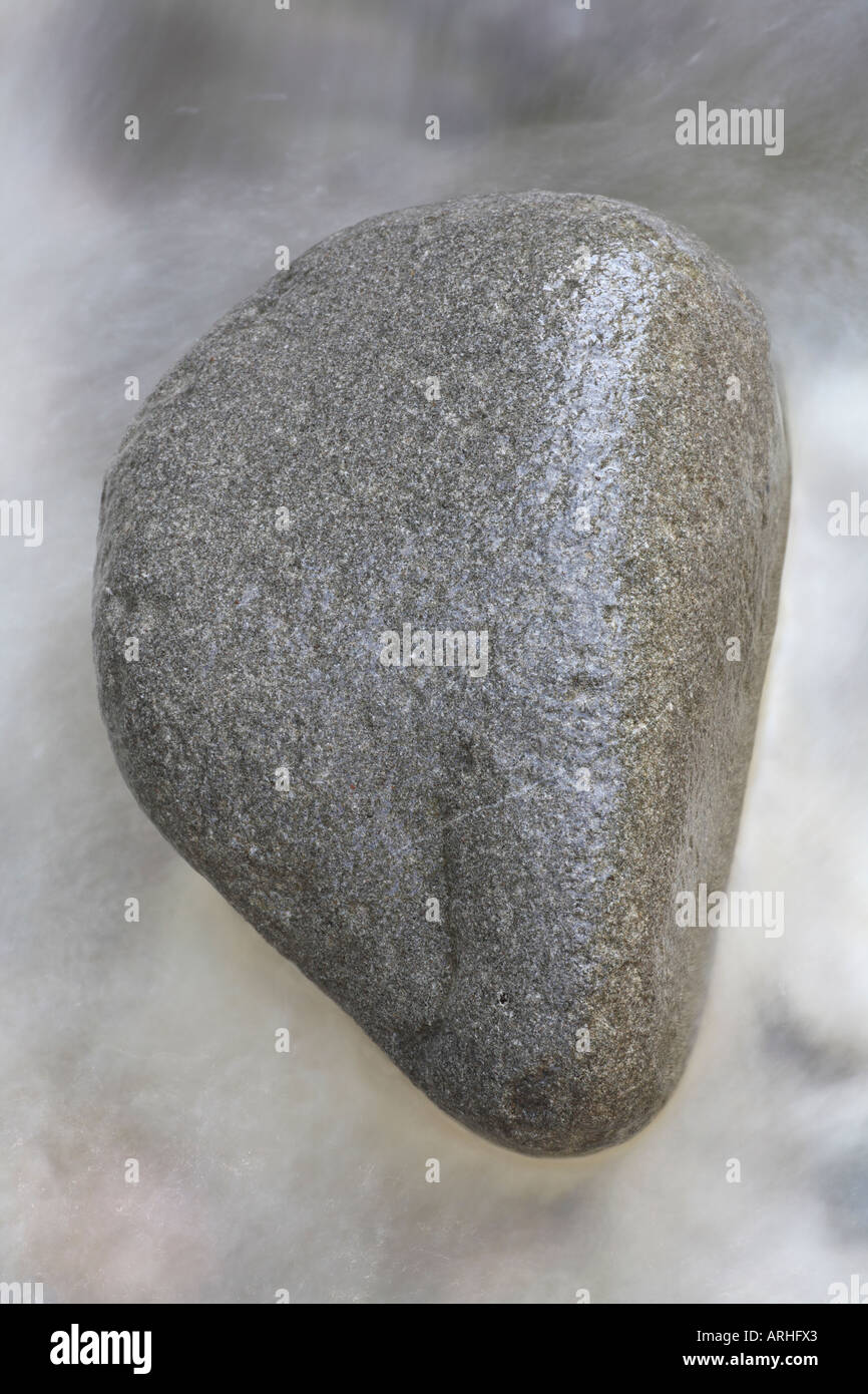 Stone in flowing water Stock Photo - Alamy