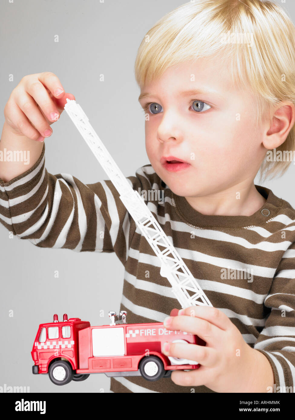 Little boy playing with fire truck Stock Photo - Alamy