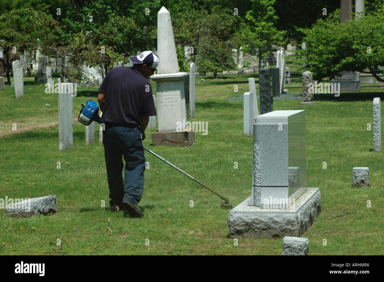 Worker cutting grass in the Grove Street Cemetery National Historic ...