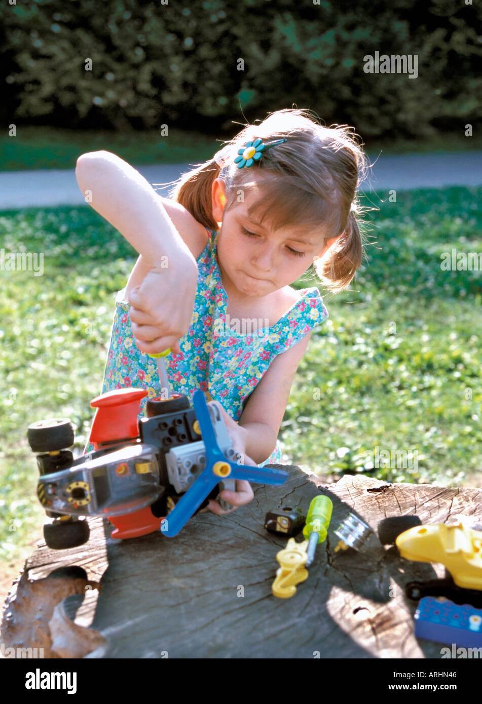 girl fixing a toy MR8381A Stock Photo - Alamy