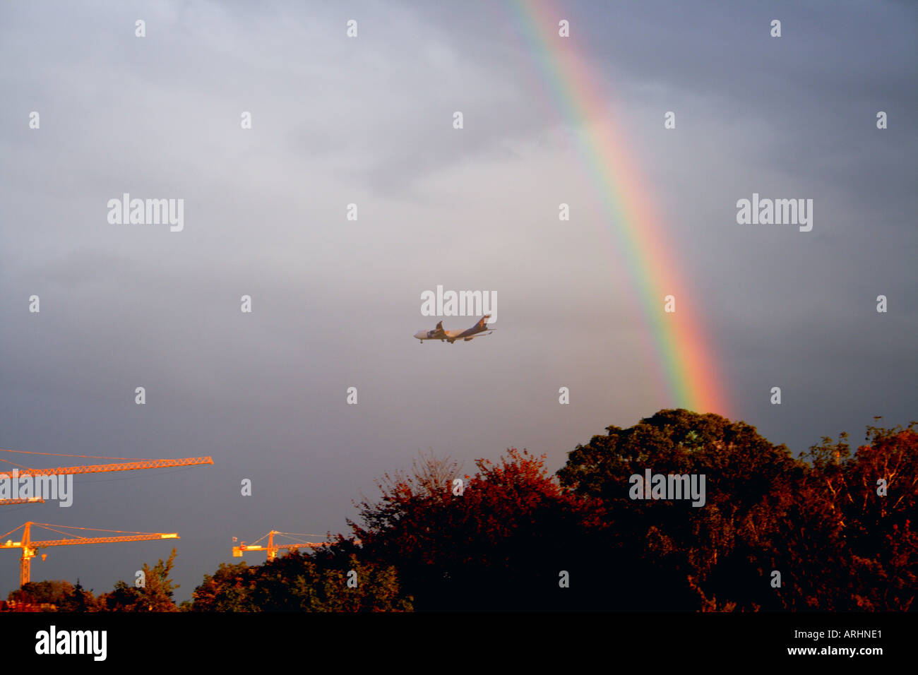 Plane landing and a rainbow in the sky Stock Photo - Alamy