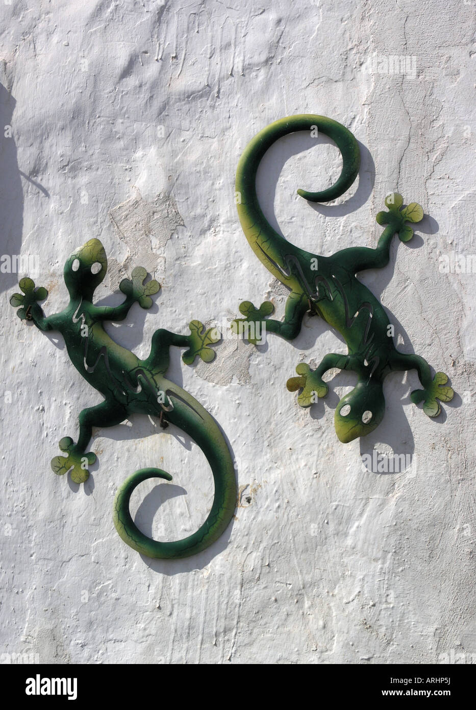 Two metal lizards on a white wall Stock Photo - Alamy