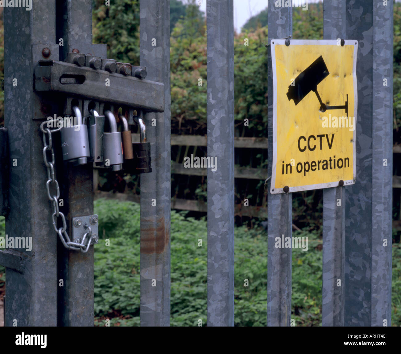 Five padlocks and CCTV warning sign on a gate Stock Photo - Alamy