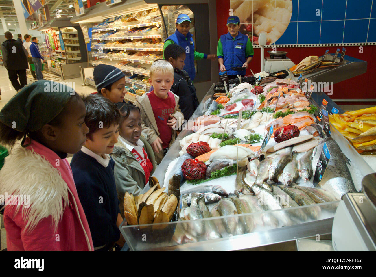 SCHOOL CHILDREN IN THE SUPERMARKET LOOKING TO THE FRESH FISH OCTOBER ...