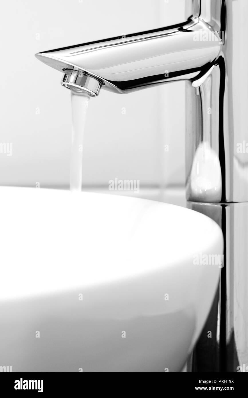 Chrome Tap With Flowing Water Into Whit Basin And Tile In Bathroom [rf