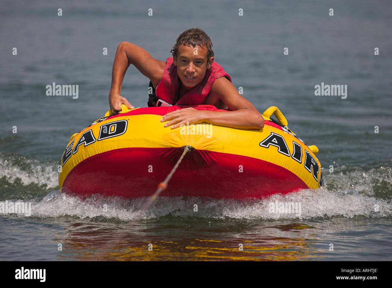 Boy riding a water tube Stock Photo - Alamy