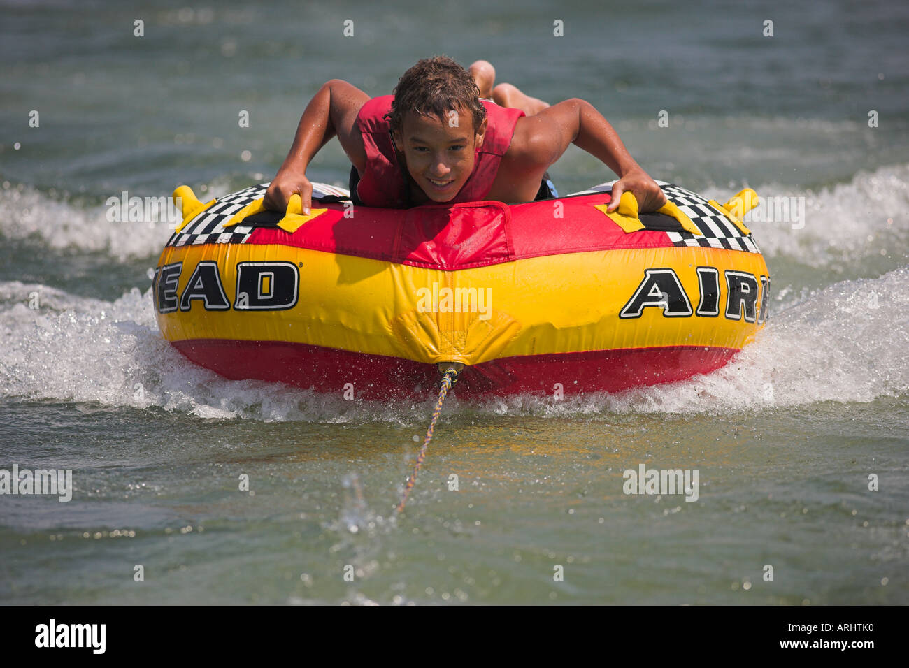 Boy riding a water tube Stock Photo - Alamy