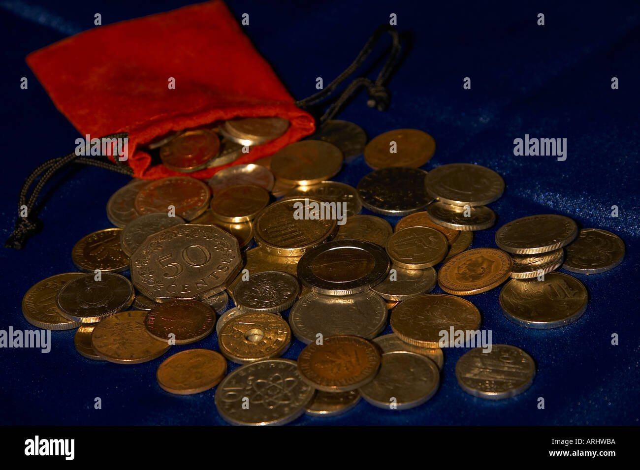 Coins spilling from a red bag Stock Photo - Alamy