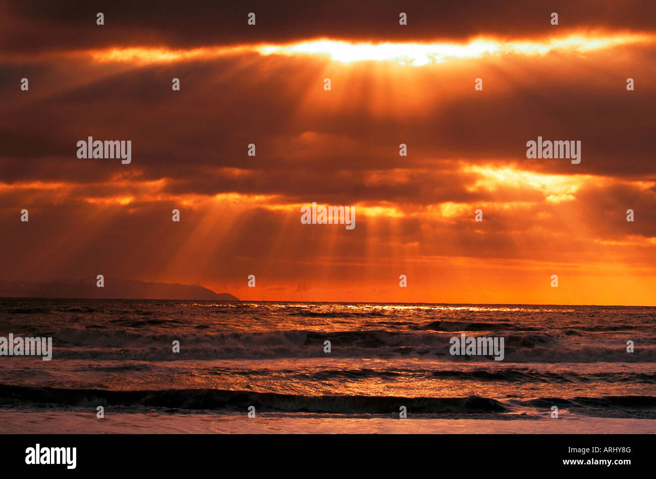 Sun rays over the ocean at sunset Stock Photo - Alamy