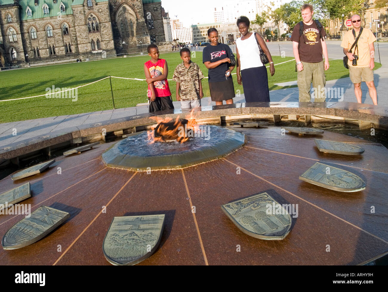 Tourists looking at the Centennial Flame at the entrance to Parliament ...