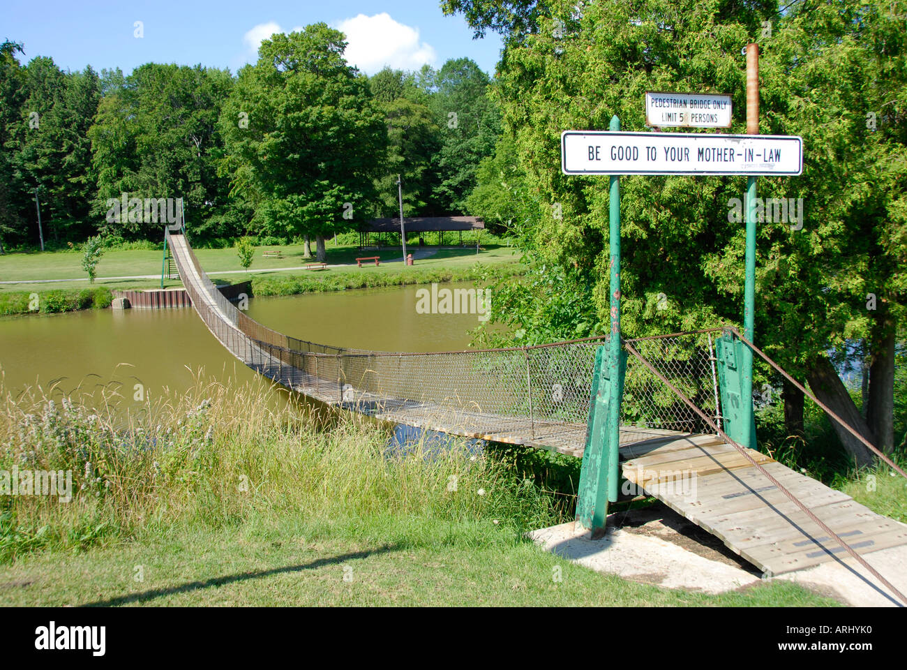 Family walks across a swinging suspension foot bridge at Croswell ...