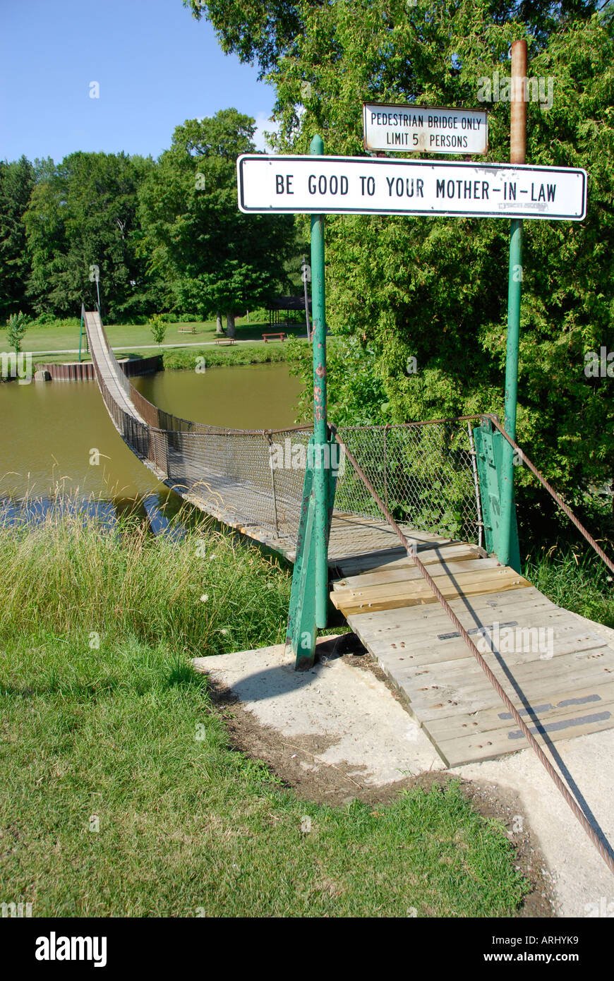 Family walks across a swinging suspension foot bridge at Croswell ...