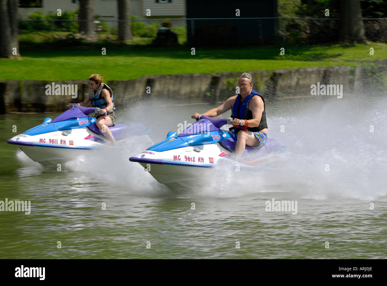 Father and daughter ride wave runners on the water for fun and pleasure ...