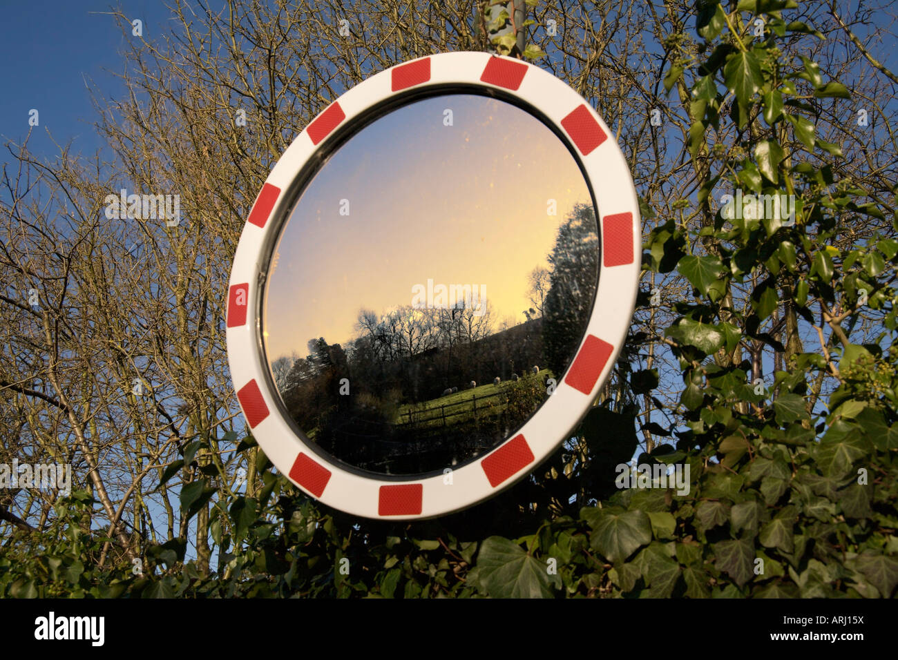 A traffic mirror reflecting a rural sunset Stock Photo - Alamy