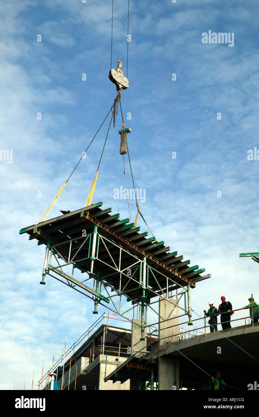 Prefabricated section of a building being hoisted into place by a large ...