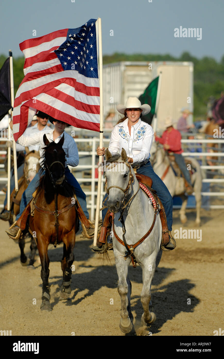 Female cowgirl rides a brama bull carrying flag in the ceremony ...