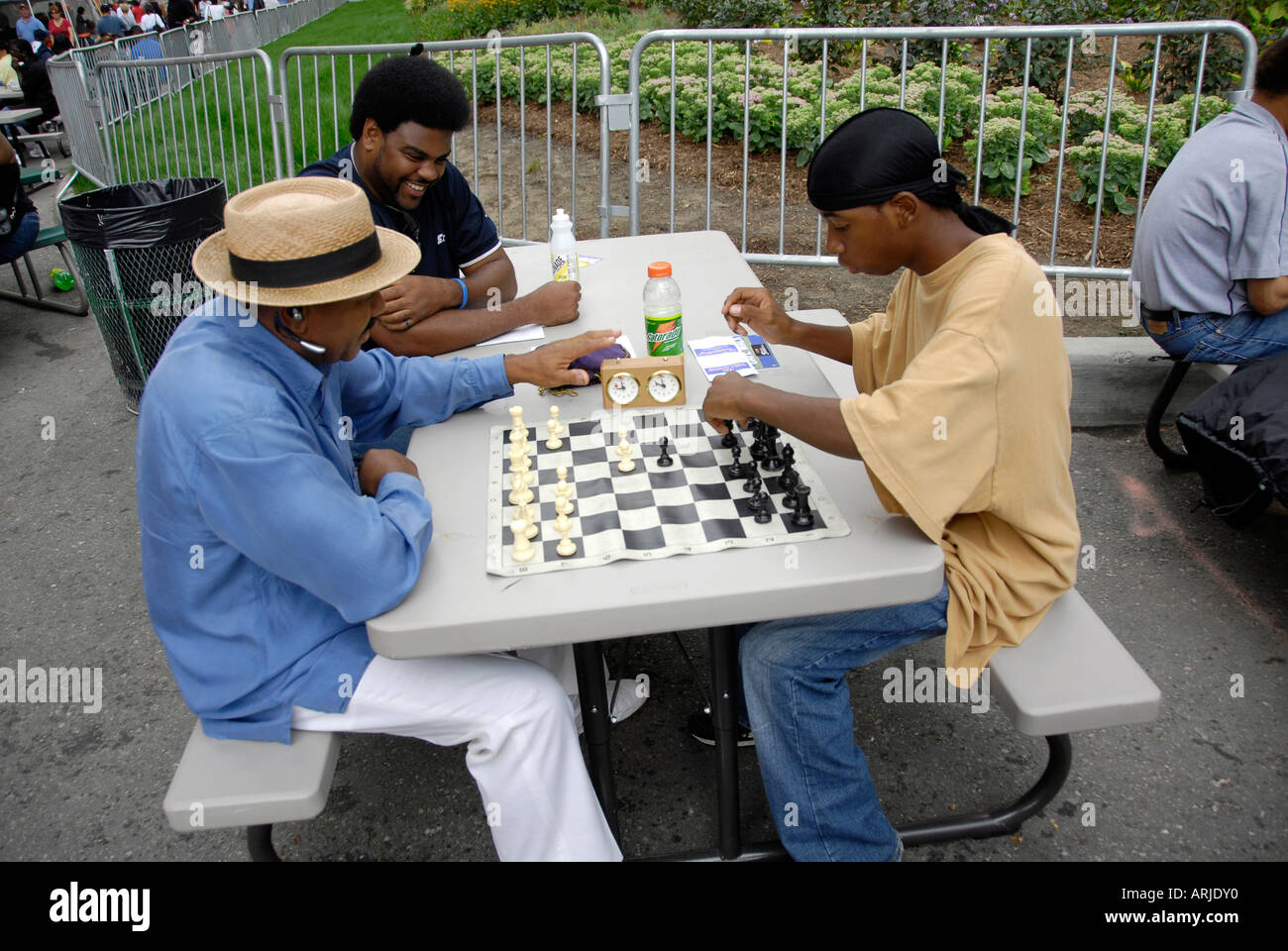Adult men looks over game pieces on a chess board as they play chess in ...