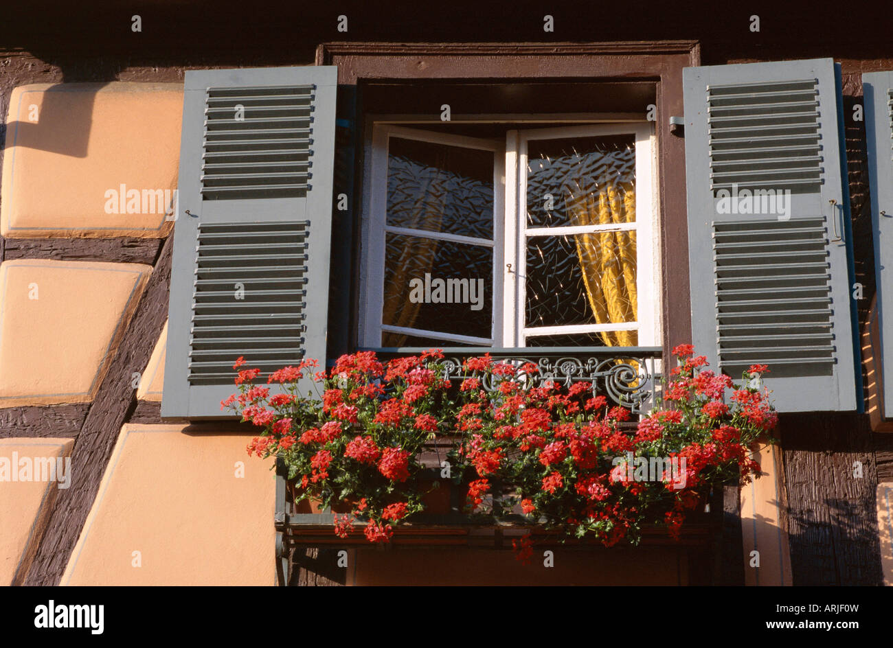 Close-up of typical window with blue shutters and windowbox full of ...