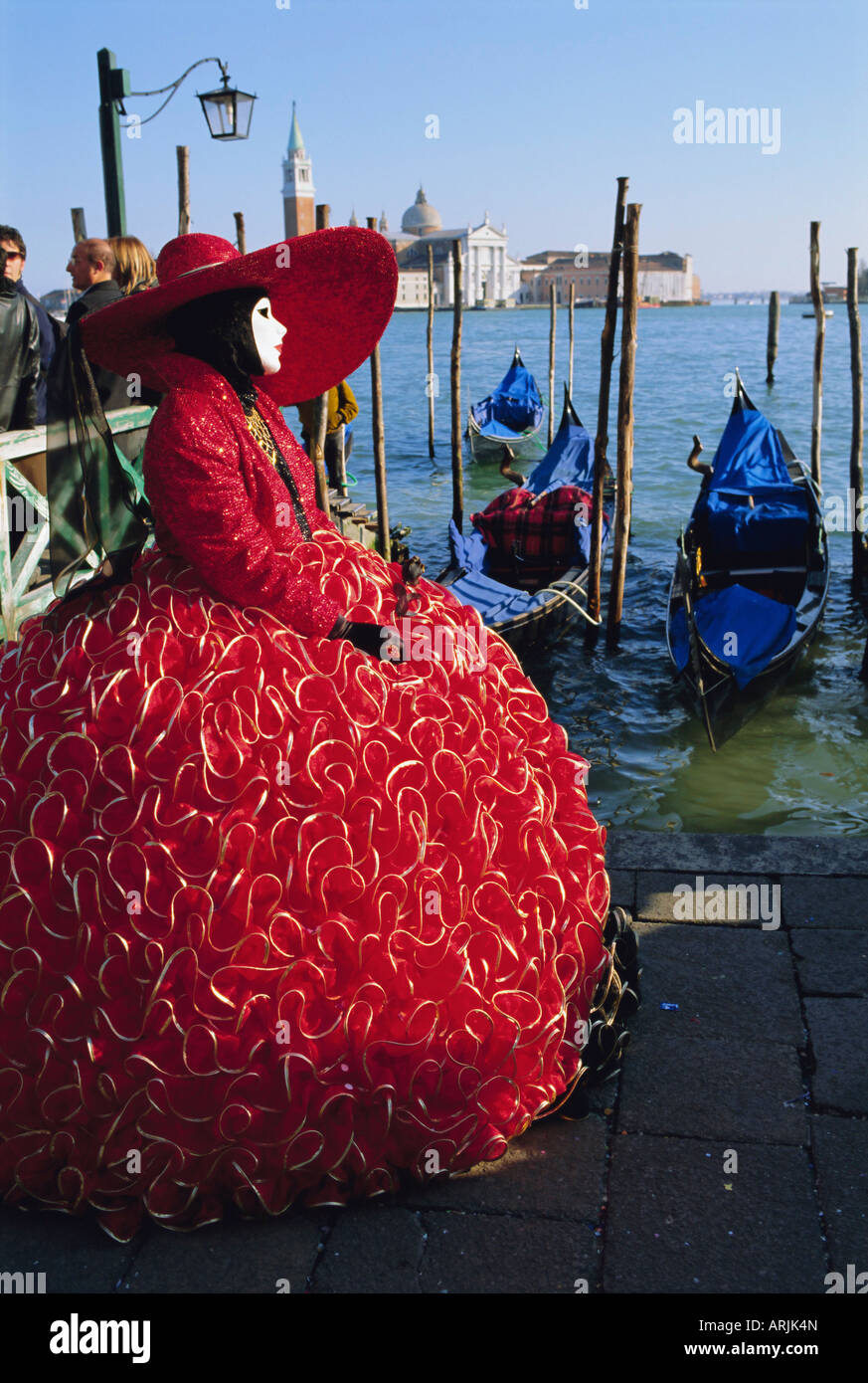 Person wearing masked carnival costume, San Giorgio in the background ...