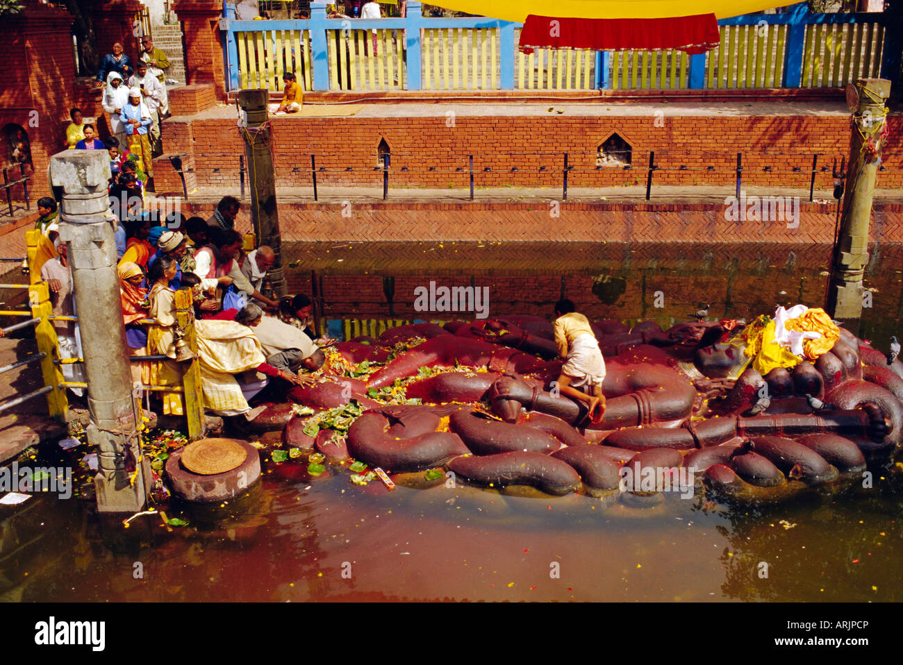 Hindus praying and giving offerings to a giant statue of Vishnu, near ...