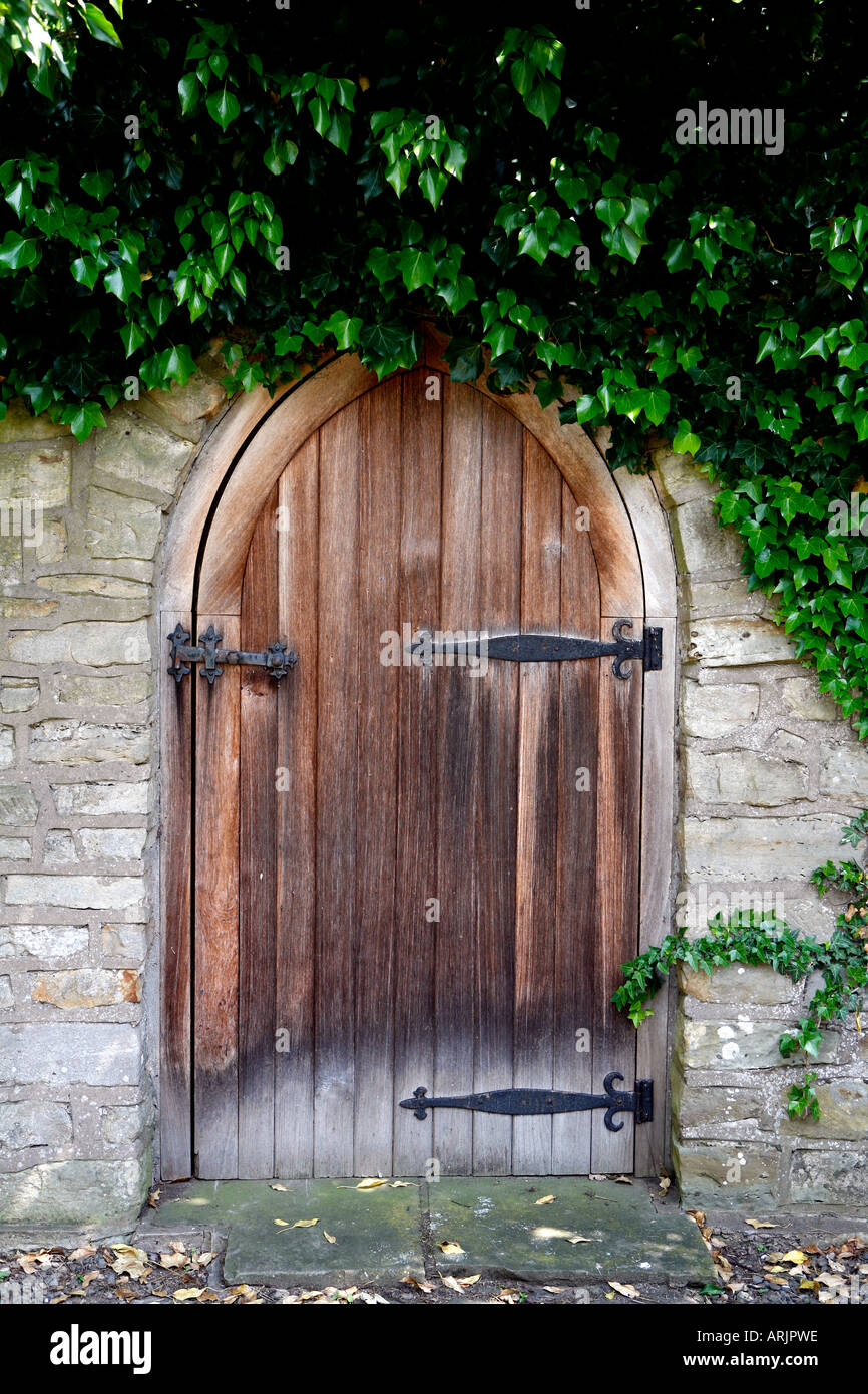Wooden Gate in a wall under ivy Stock Photo - Alamy