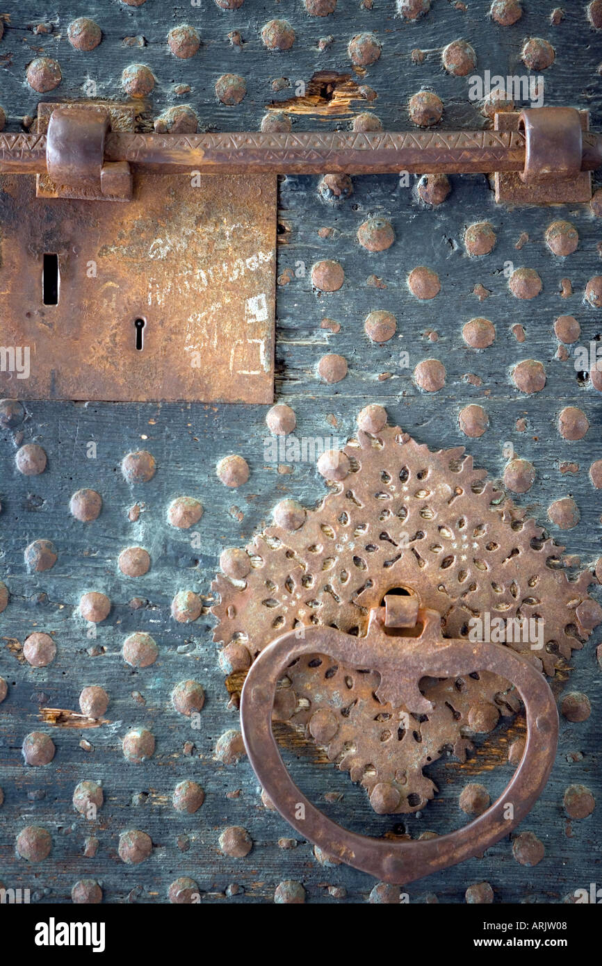 Fortified door with scarred metal bolts and decorative knocker ...