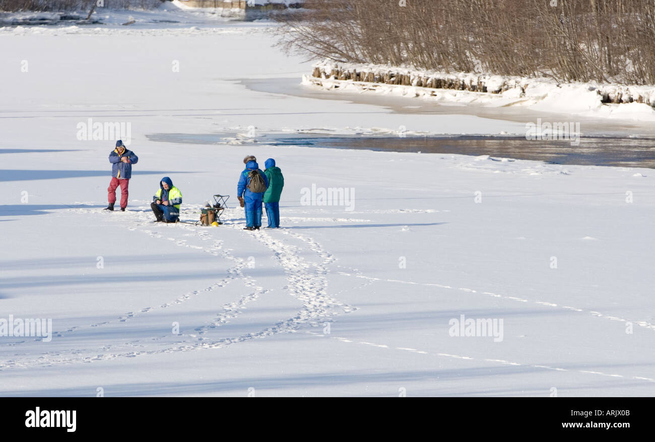 Group of people ice-fishing white fish at Oulujoki river at Winter ...