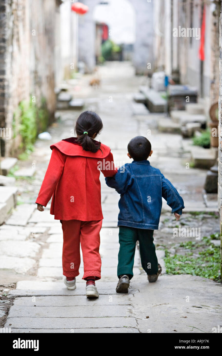 Girl walking with her brother in an alley, Cheng Kan, China Stock Photo ...