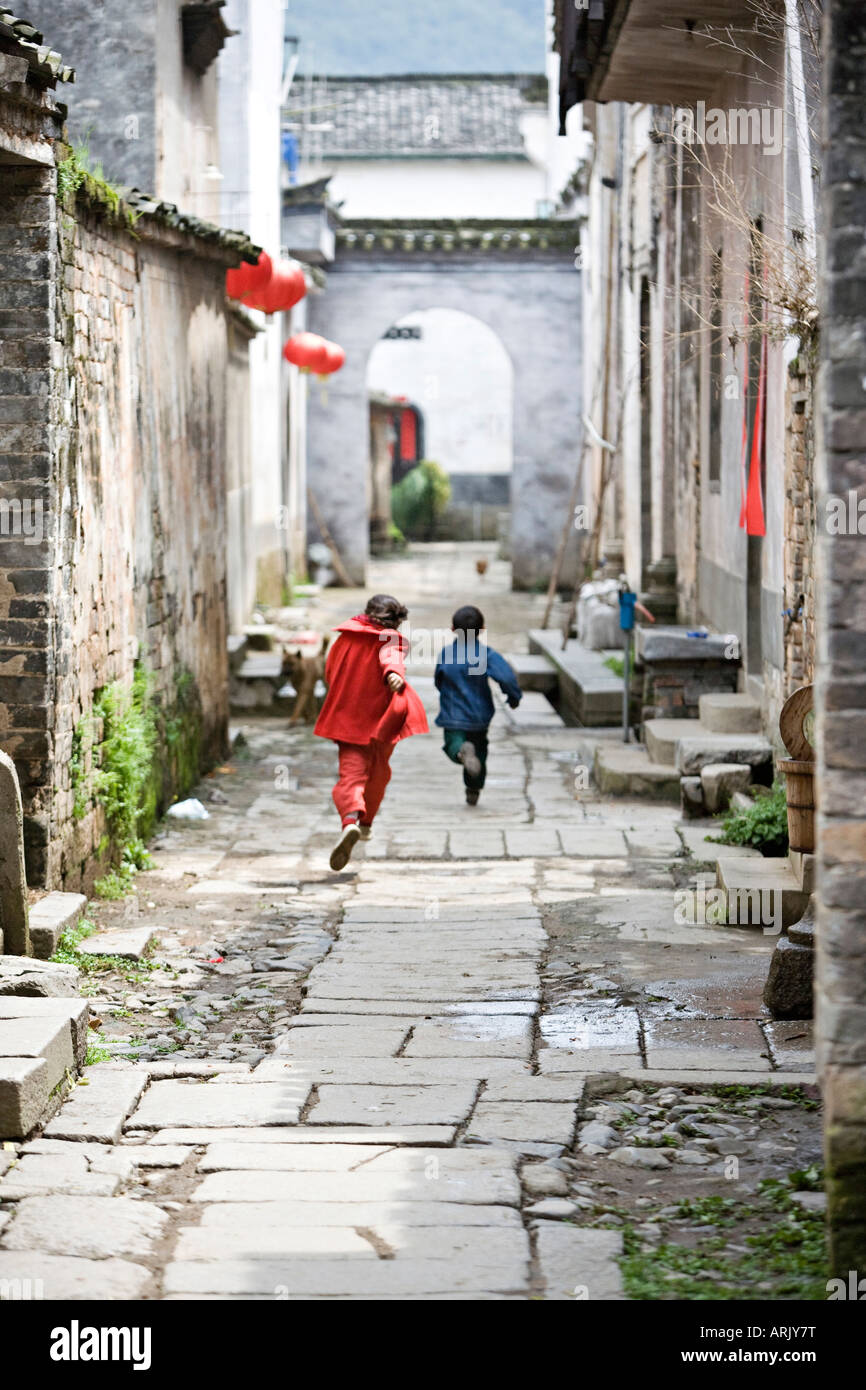 Girl and her brother running in an alley, Cheng Kan, China Stock Photo ...