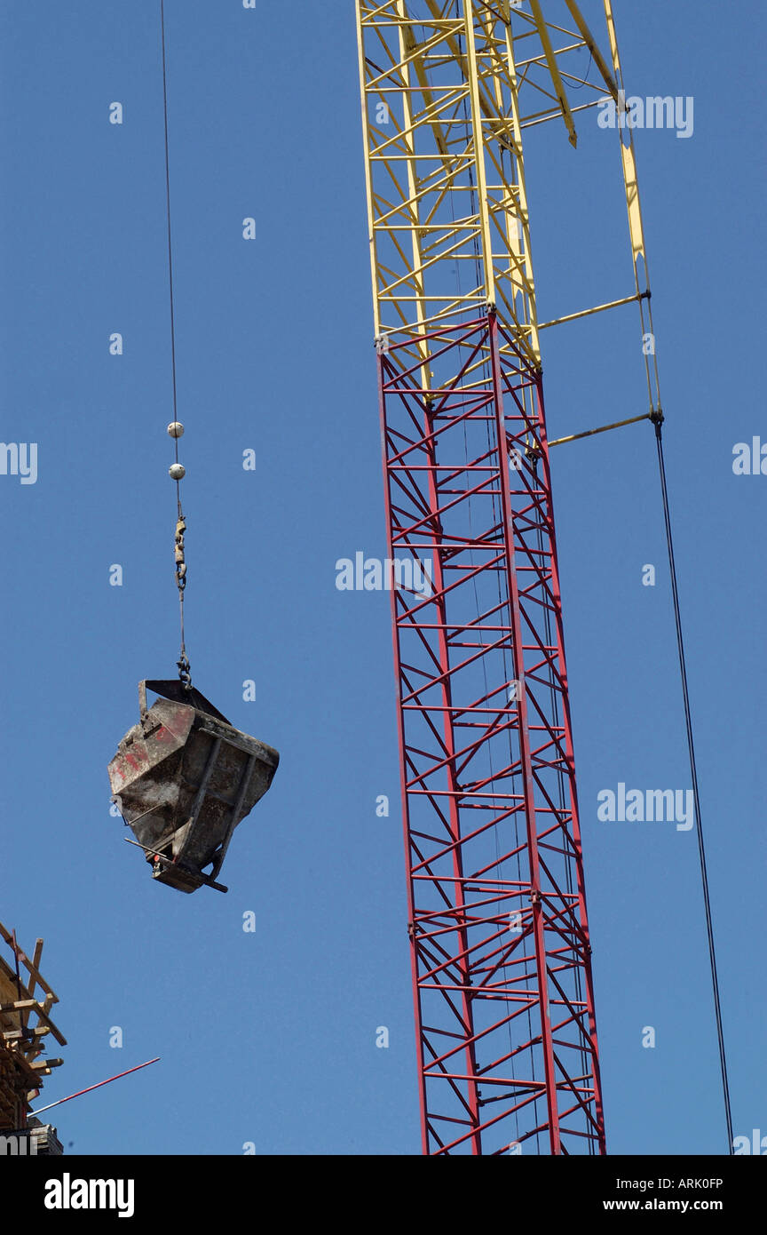 Low angle view of a crane hoisting a cement mixer Stock Photo - Alamy