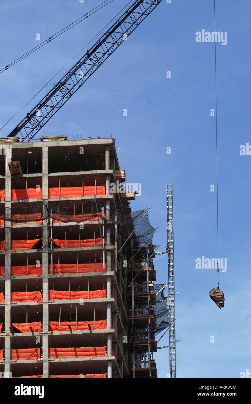 Crane hoisting a cement mixer at an apartment building under ...